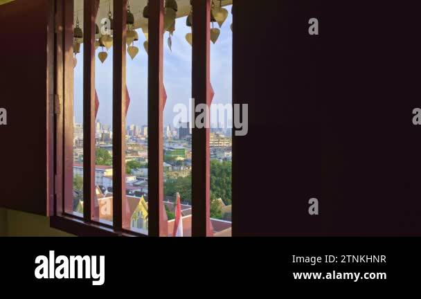 Underexposed traditional Thai window frame with bars and bells with ...