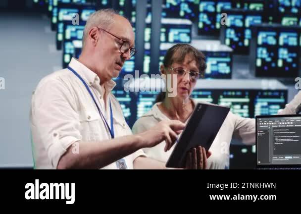 Organized Admins In High Tech Workspace Completing Tasks On Tablet While Running Scripts On