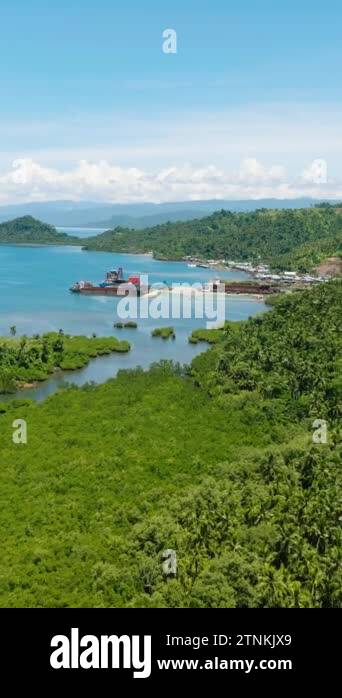Beautiful sea port with cargo ship in tropical island. Blue sky and ...