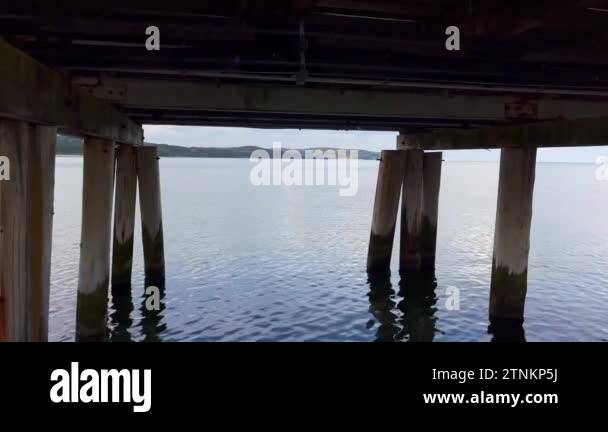 Sea Water under an ocean pier. View under bridge, small waves ocean ...