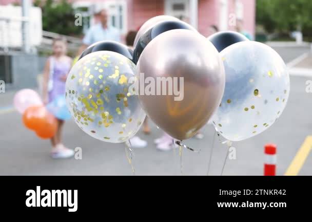 A String of Balloons Hanging Between Trees in a Park for a Birthday ...