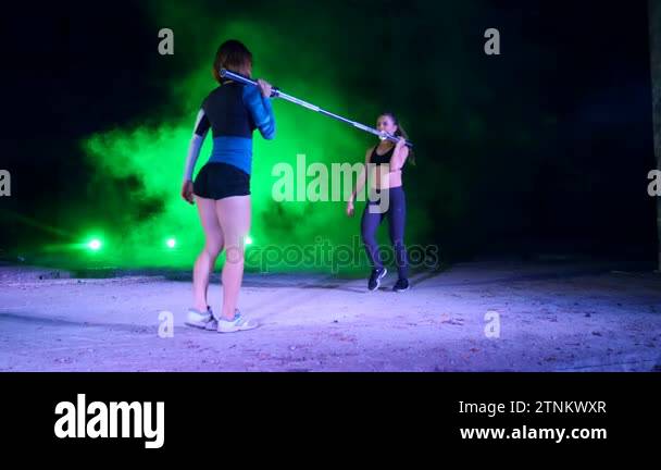 Two Athletic Girls In Pair Doing Various Strength Exercises With A Barbell Squats At Night In