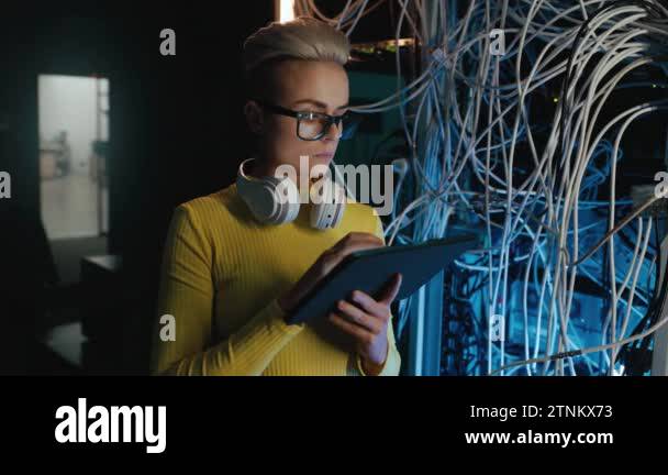 IT woman working at server room using mobile tablet. Maintaining ...