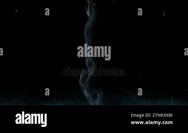 Stream of white paint poured in dark water seems a soft smoke rapidly ...