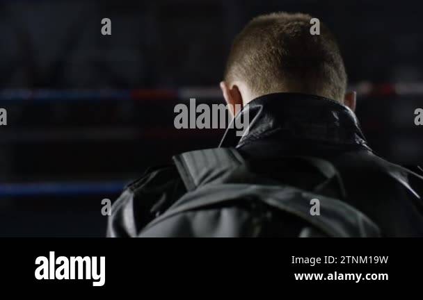 Back view of traveling handsome man in jacket with suitcas looking up ...
