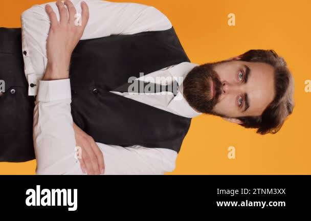 Vertical video Restaurant waiter poses in studio, feeling confident ...