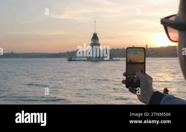 Man traveler photographing Maidens Tower in Bosphorus strait in ...