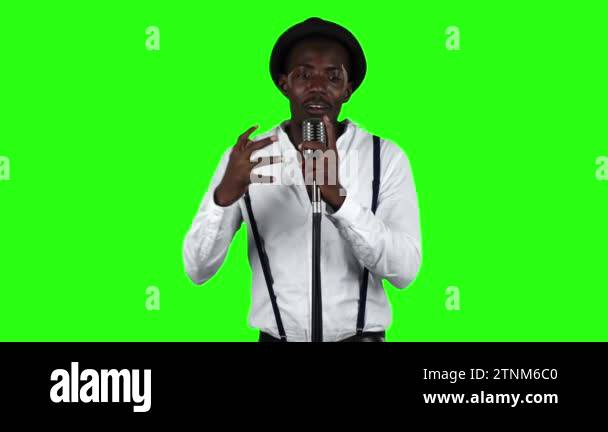 Singer sings into a retro microphone spinning and dancing around him ...