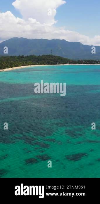 A tropical beach with palm trees and a blue ocean. Pagudpud, Ilocos ...