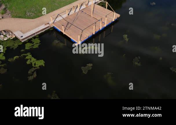 Pier for park visitors. two steps lead to it. planks terrace over water ...