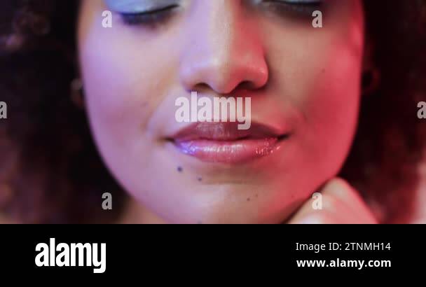 Biracial woman with dark hair in blue and pink light, slow motion ...