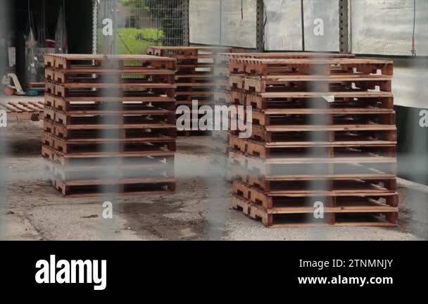 tight shot, piles of wood palettes skids, pavement, outdoor canopy tent ...