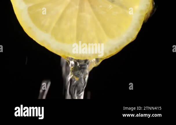 Super slow motion shot of sliced lemon slices with splashes of water ...
