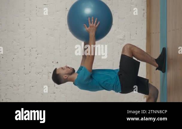 Vertical video. Side view. Athletic male fitness coach doing exercises ...