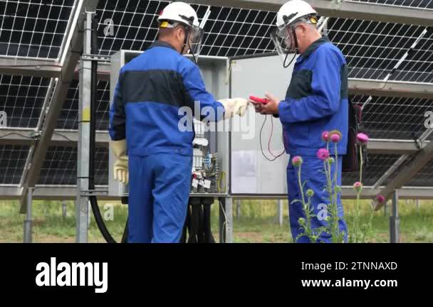 Two Service Engineers or electrician working on checking transformer ...