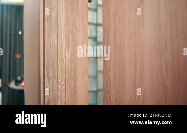 an Asian man is spying on his girlfriend while in the bathroom of a hotel room at night Stock ...