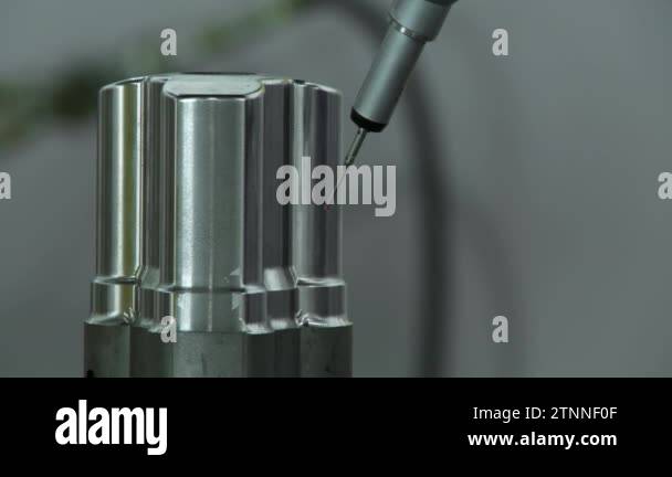 Detail of a measuring device checking a machined metal block as part of ...