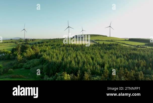 An aerial view of a windmill farm for energy production in a beautiful blue sky on an elevated ...