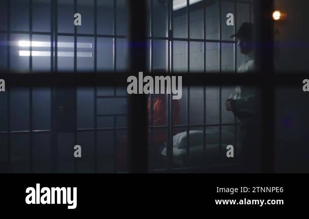 Male prisoner hits prison officer, takes keys, opens prison cell. Criminal in orange uniform ...