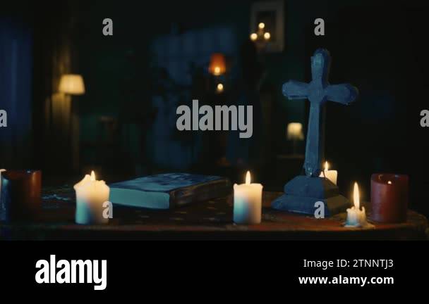 Video capturing a table with magical tools on it: candles, cross and a ...