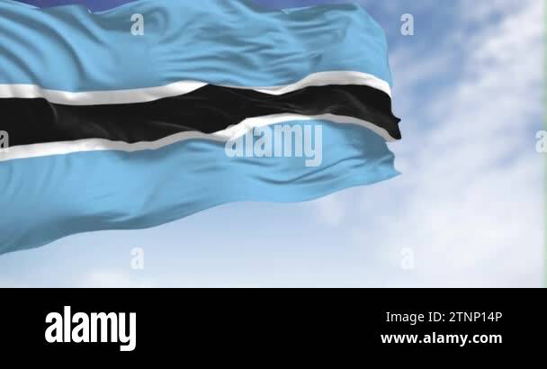 National flag of Botswana waving on a clear day. Light blue field with ...