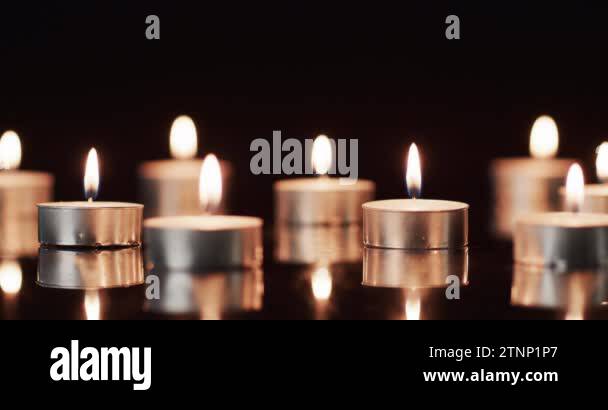 Video of rows of tea candles with white flames and copy space on black ...
