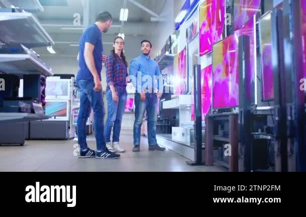 In the Electronics Store Professional Consultant Approaches Young ...