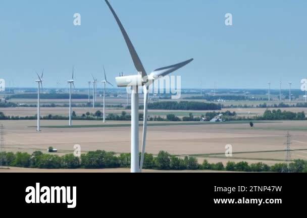 Video of Aerial video pan from top of one wind turbine to blades of the ...