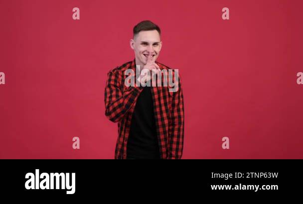 On the vibrant red background, the playful Caucasian man is making the ...
