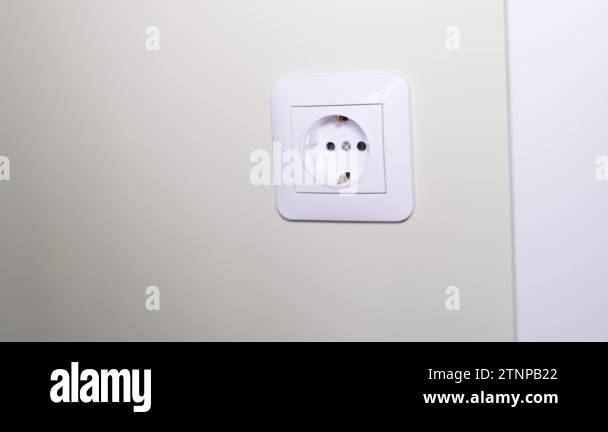 A mans hand connecting a black power supply unit to an electrical ...