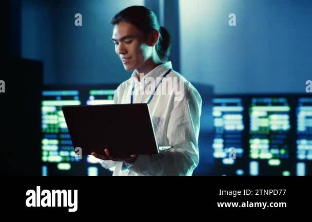 Skillful employee walking through data center systems providing processing resources for ...