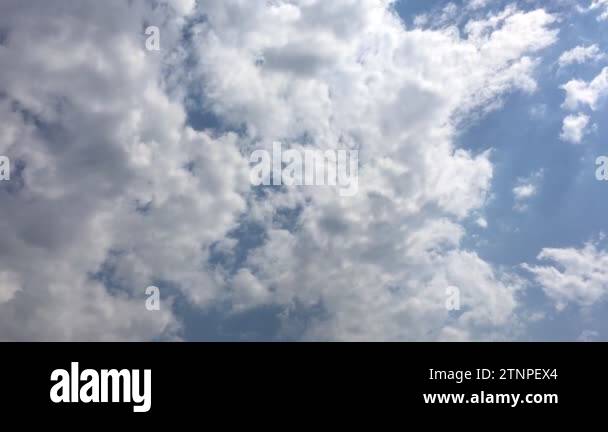 White clouds disappear in the hot sun on blue sky. Time-lapse motion ...