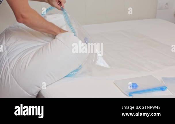 Cropped shot of unrecognizable man sucking air from compression bag ...