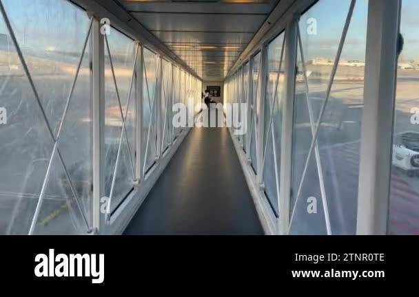 Passenger POV boarding plane inside airplane bridge. Person entering ...