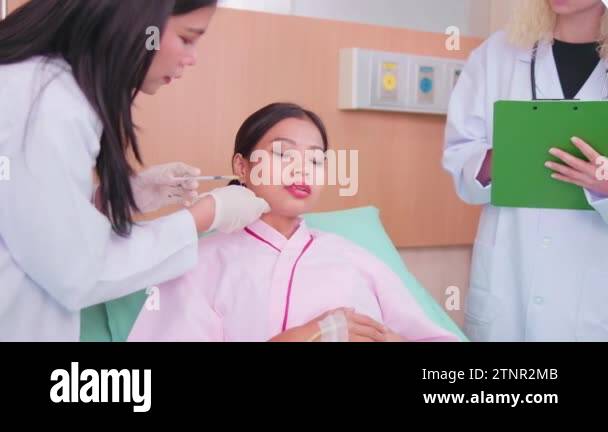 Asian female cosmetic doctor inject Botox into face of woman patient ...