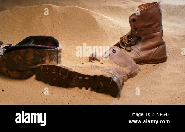 Parts of a soldier's uniform lay in the sand. Ruins after the war ...