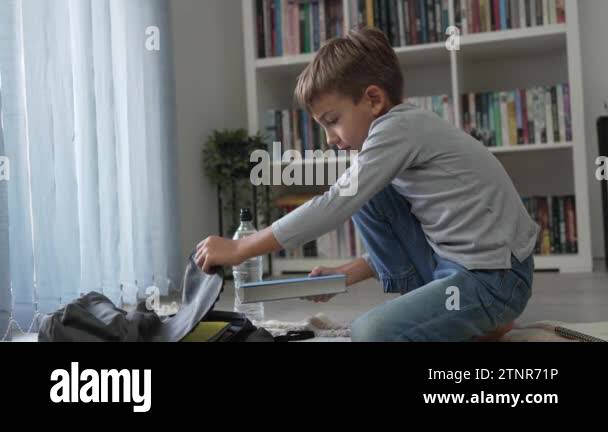 Small caucasian boy pupil child prepare his backpack for first day of ...