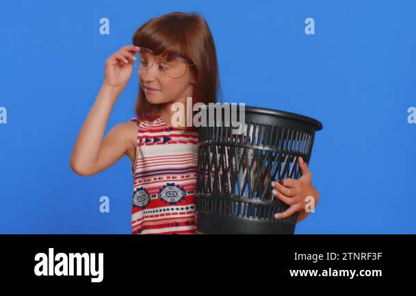 Young school girl taking off, throwing out glasses into bin after ...