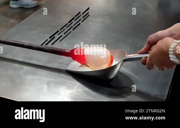 Adding colour powder to glass blowing melted hot glass with first ...