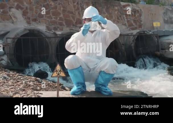Ecologist sampling water toxic chemicals from river with test tube ...