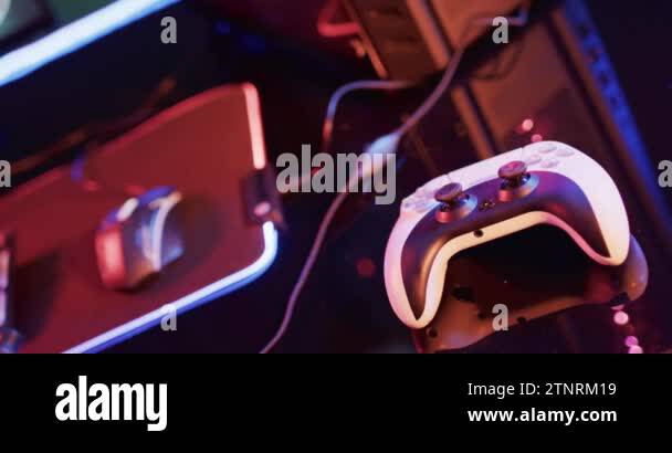 Video of computer and gaming equipment on desk with copy space on neon ...