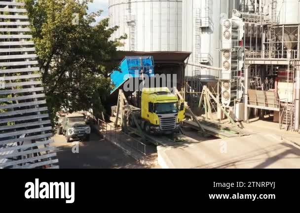 Grain dump truck or lorry unloading on elevating hydraulic platform ...