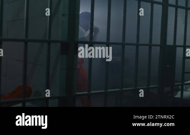 Male African American prisoner in orange uniform does shadow boxing in ...