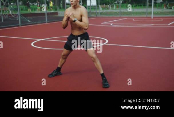Athletic man training at sports court outdoors and doing side lunges ... Athletic man training at sports court outdoors and doing side lunges ...