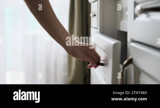 A woman opens the dresser drawer and skillfully begins to fold and ...