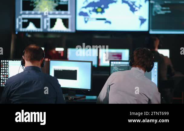 Team of security personnel watching the screens in a system control ...