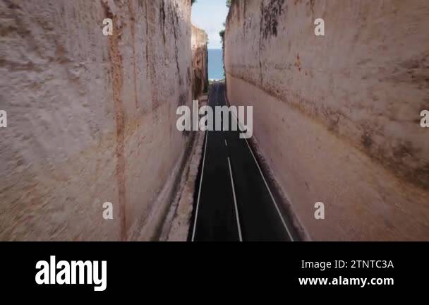 Aerial drone flying back over asphalt road with lines, passing between ...