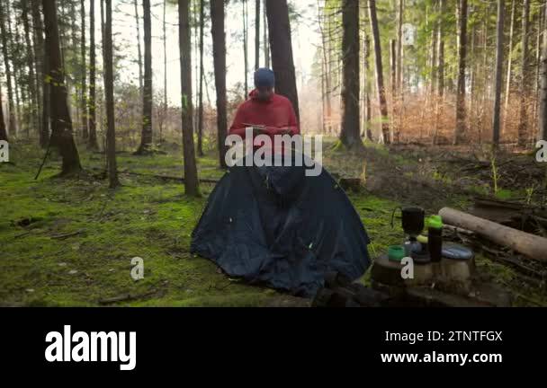 Man hiker sets up camping tent in the fall forest on backpacking ...