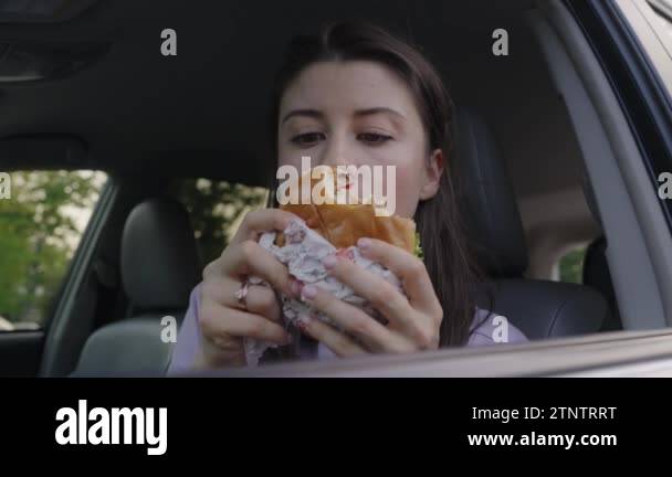 Woman eating delicious burger having nutritious snack for lunch in ...