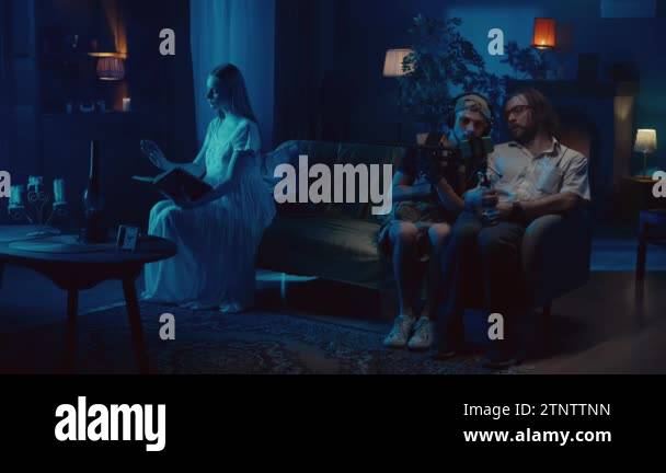 Video of two ghost hunters sitting on the side of the couch trying to ...